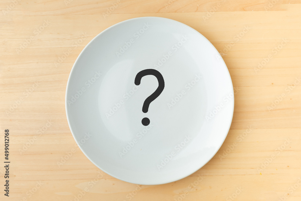 Empty white plate with question mark on wooden table. background for ...