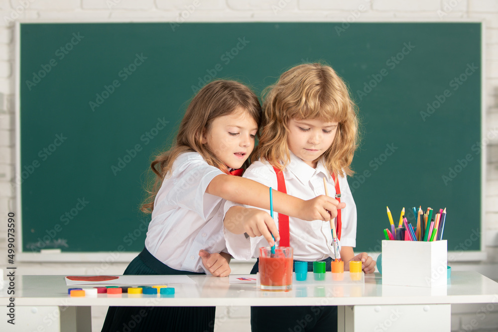 School children drawing a colorful pictures with pencil crayons in ...