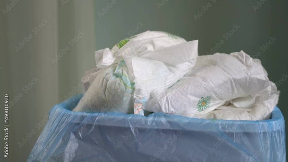 Dirty baby diapers into the trash. Disposing of used nappies ...