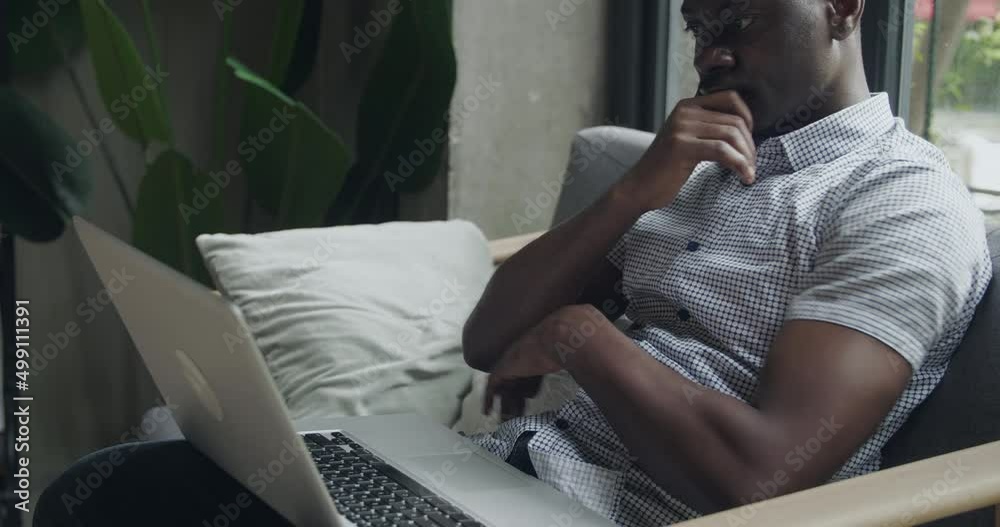 Close up side view of one black man using laptop in the office African ...