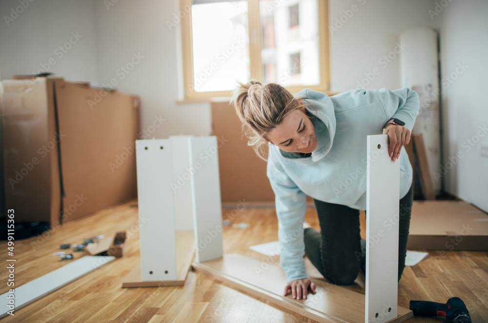 Woman assembling furniture at home Stock Photo | Adobe Stock