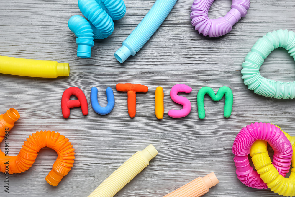 Word AUTISM with Pop Tubes on grey wooden background Stock Photo ...