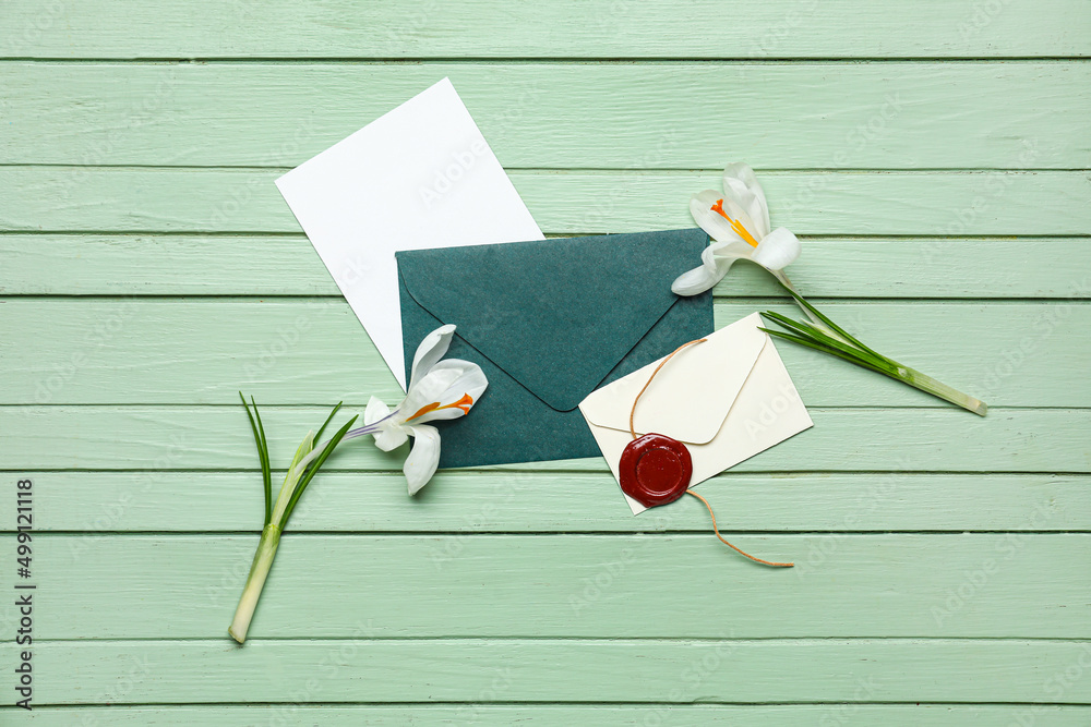 Envelopes with card and flowers on green wooden background Stock Photo ...
