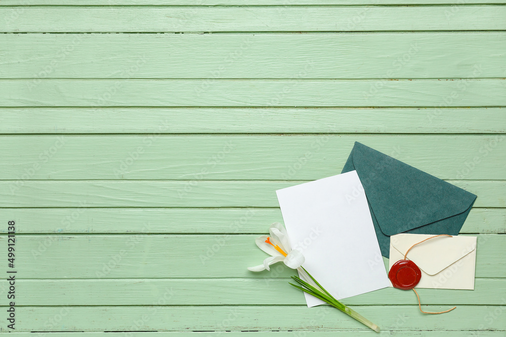 Envelopes with card and flower on green wooden background Stock Photo ...