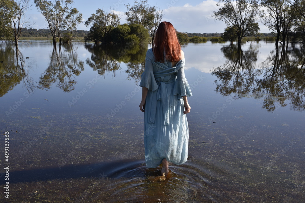 Portrait of beautiful girl wearing flowing fantasy gown in a magical ...
