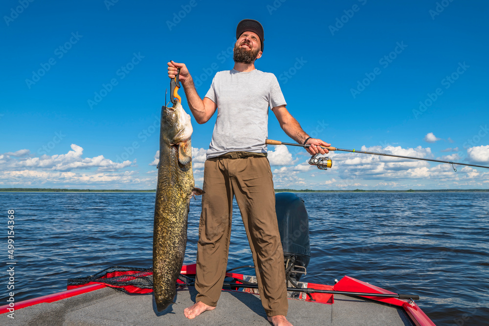 Success catfish fishing. Happy fisherman with big sheatfish trophy at ...