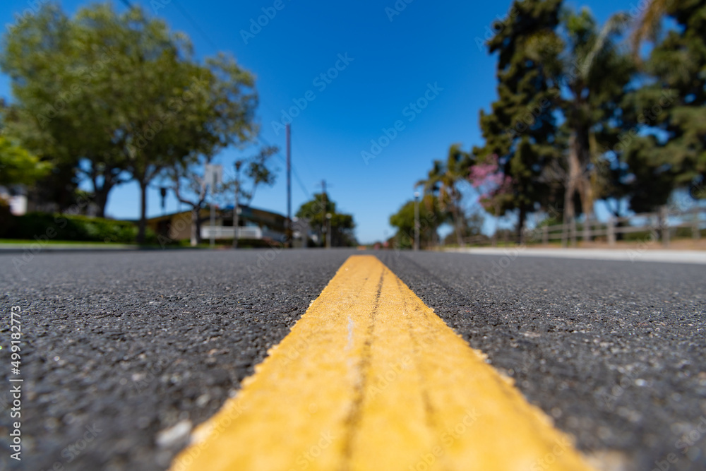 Yellow line road marking on asphalt road surface along blurry ...