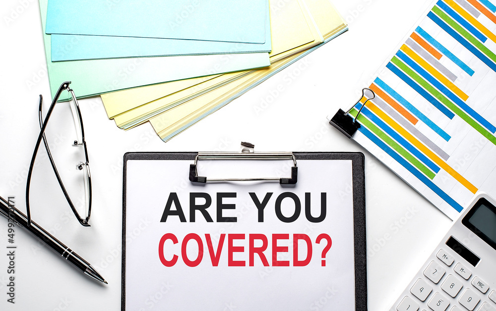 ARE YOU COVERED text on the paper sheet with chart,color paper and ...