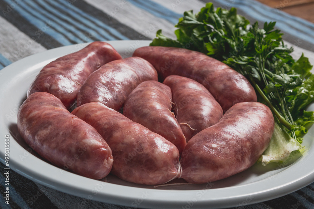 Linguiça calabresa mista porco crua em gomos grandes em prato branco ...