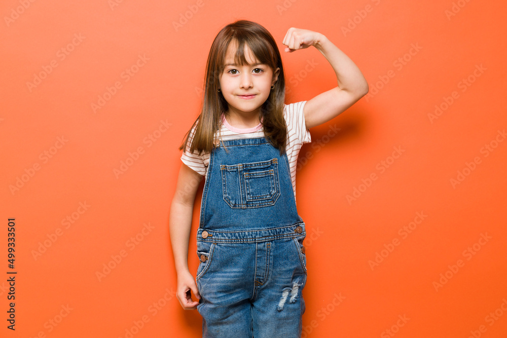 Strong little girl showing her arms Stock Photo | Adobe Stock
