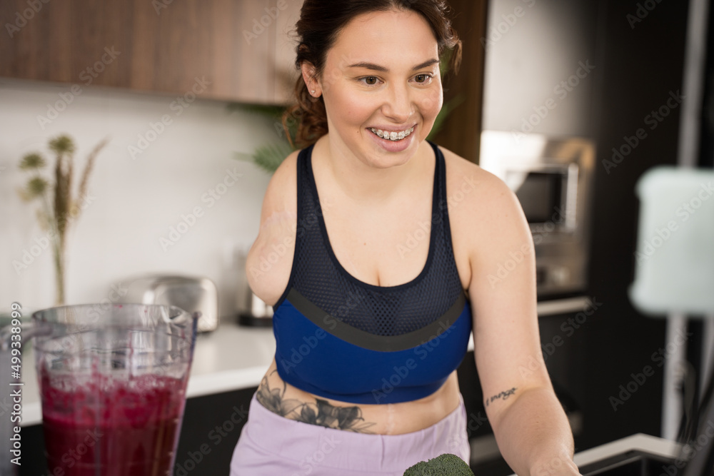 Female with braces and amputee arm smiling to the smartphone camera ...