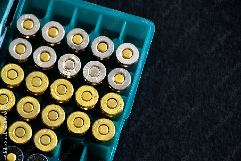 9MM pistol bullets in plastic box on black background, concept for ...