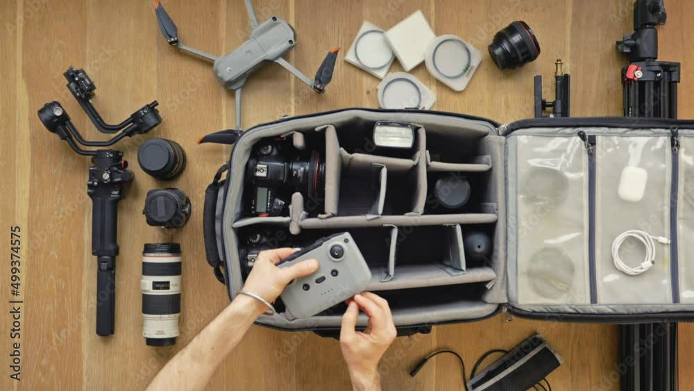 Professional photographer packs smart backpack with equipment screw the ...