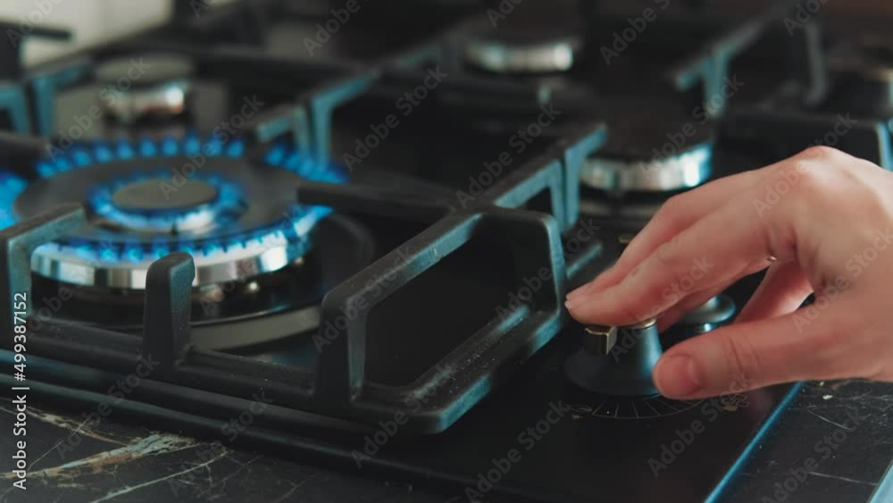 Person using kitchen burner with hand. Ignited bright blue flame, fire ...