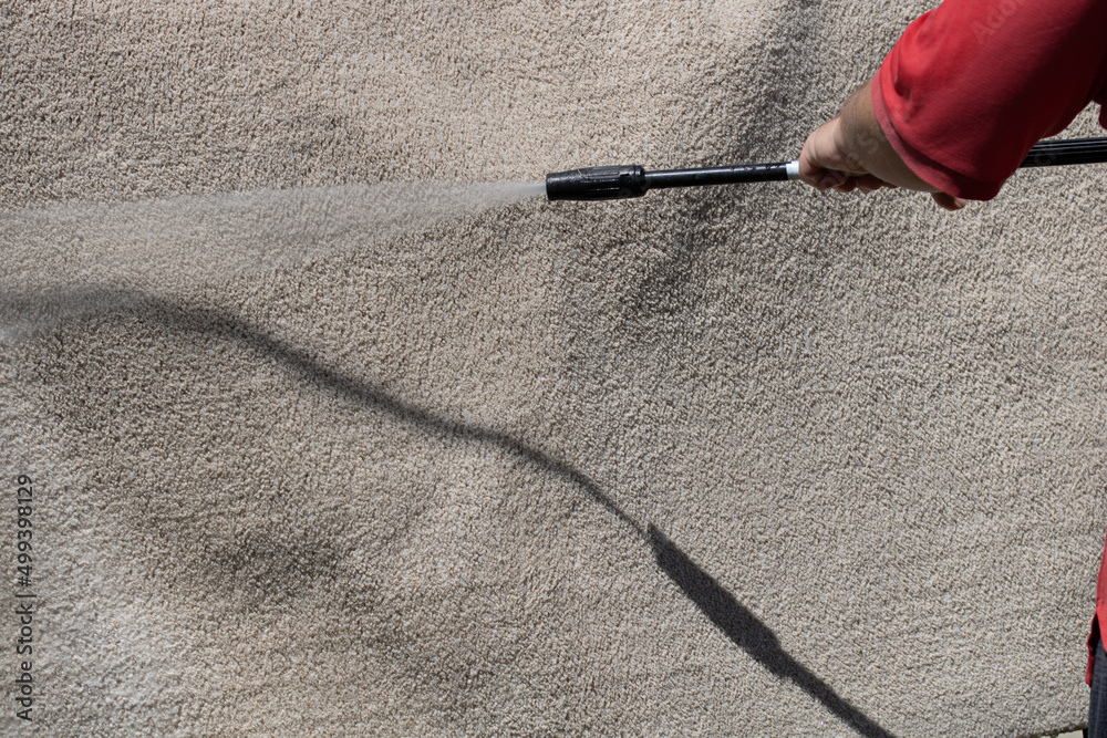 Washing carpets with high pressure washer. Cleaning the carpet with a ...