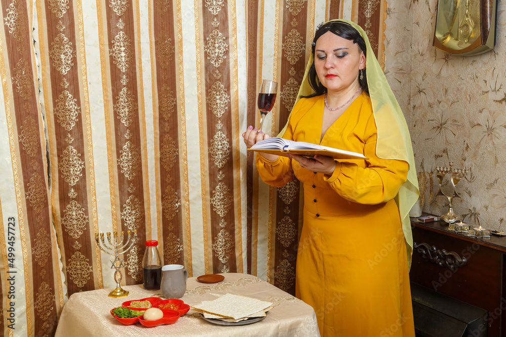 A Jewish woman in a wig and a head covering at home at the table at the ...