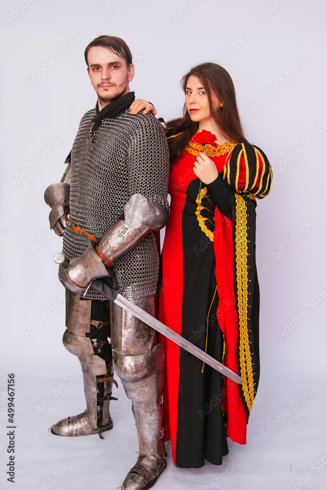 Knight in armor with a sword and a young woman in a medieval black ...