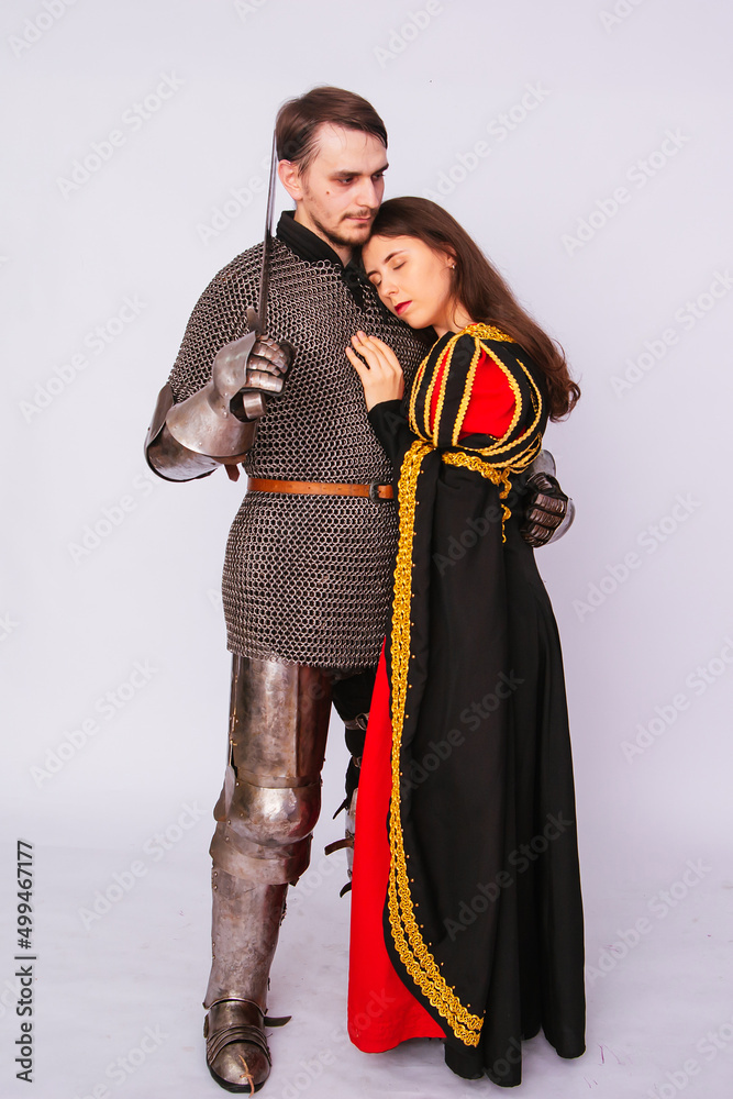Knight in armor with a sword and a young woman in a medieval black ...