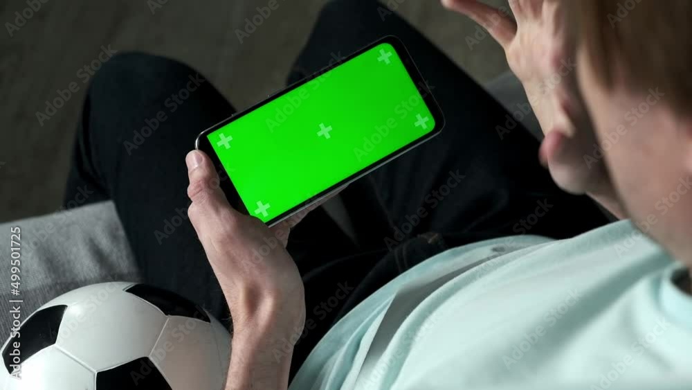 Football fan use smartphone at home with green chroma key Screen ...