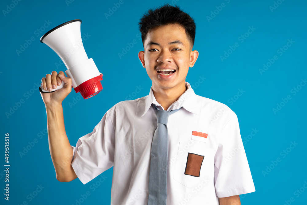High school student holding megaphone smiling at camera and wearing ...
