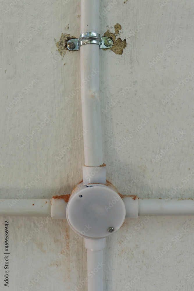 plastic pipe and four angle side pipe attached on the wall Stock Photo ...