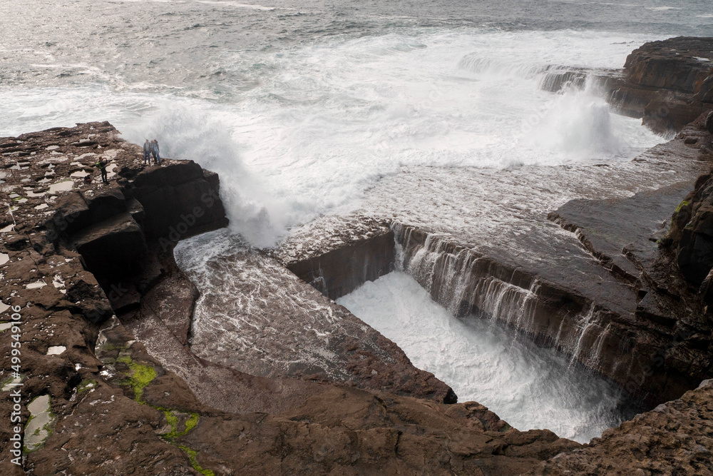 Ocean flows into The Wormhole and cliffs of Inishmore, Aran islands ...