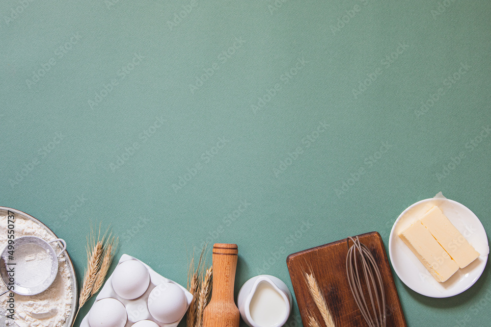 Frame of food ingredients for baking on a green pastel background ...