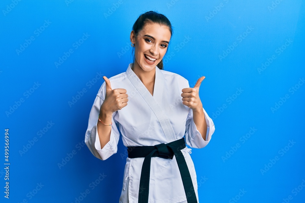 Beautiful brunette young woman wearing karate fighter uniform with ...