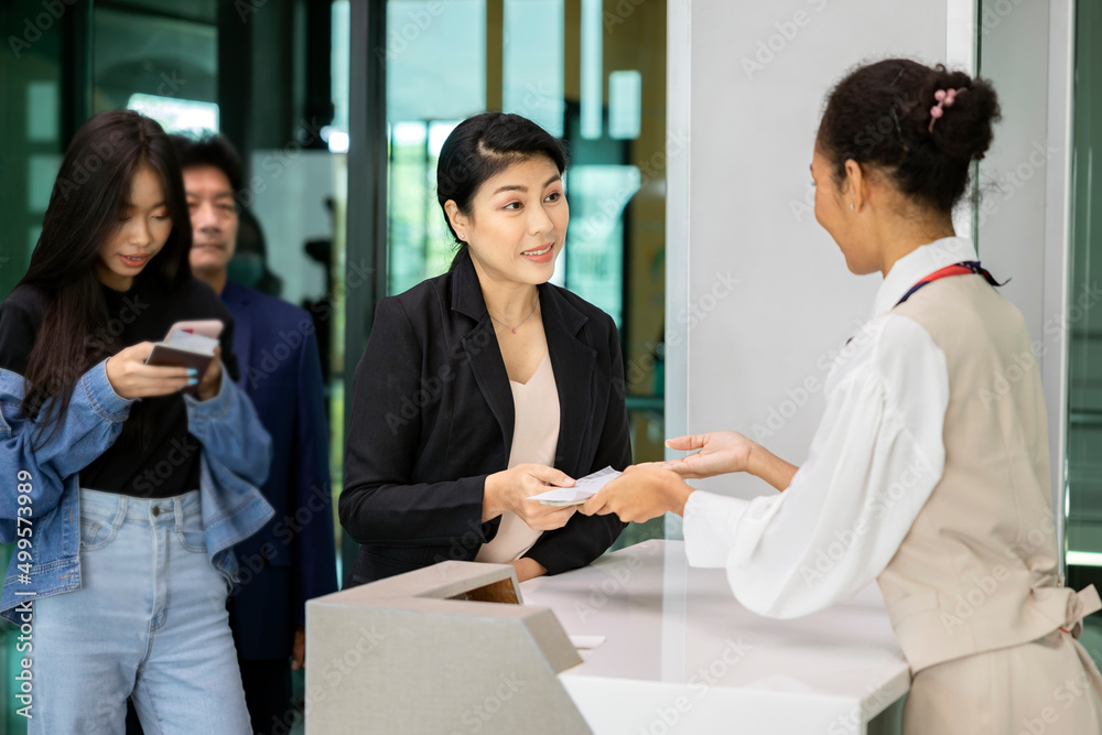 Foto de Asian businesswoman standing in queue collecting her boarding ...