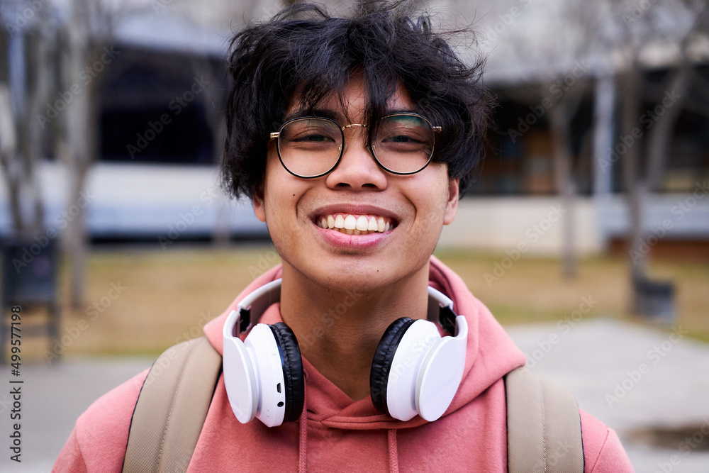 Close up shot of cheerful happy asian teenage boy looking at camera ...