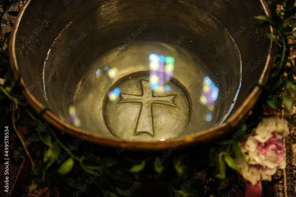 cross. detail. the cross in the baptismal font seen through the water ...