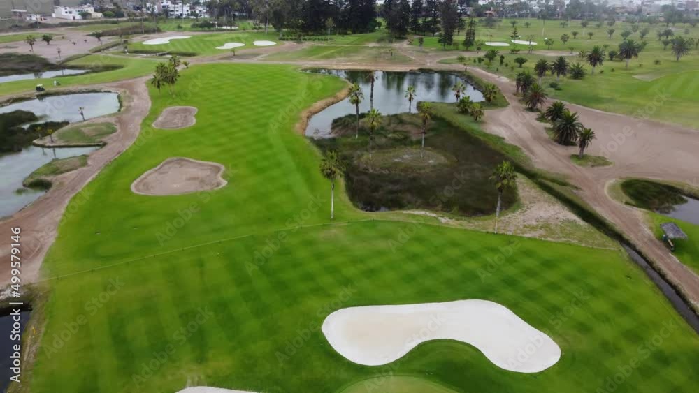Drone video of a golf course. Drone flying forward. A hole and sand ...
