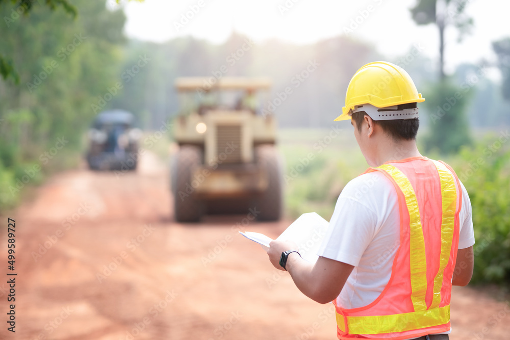 Civil engineers in reflective vests, wearing helmets, overseeing ...