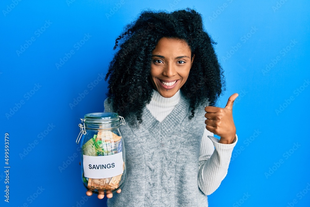 African american woman with afro hair holding savings jar with south ...