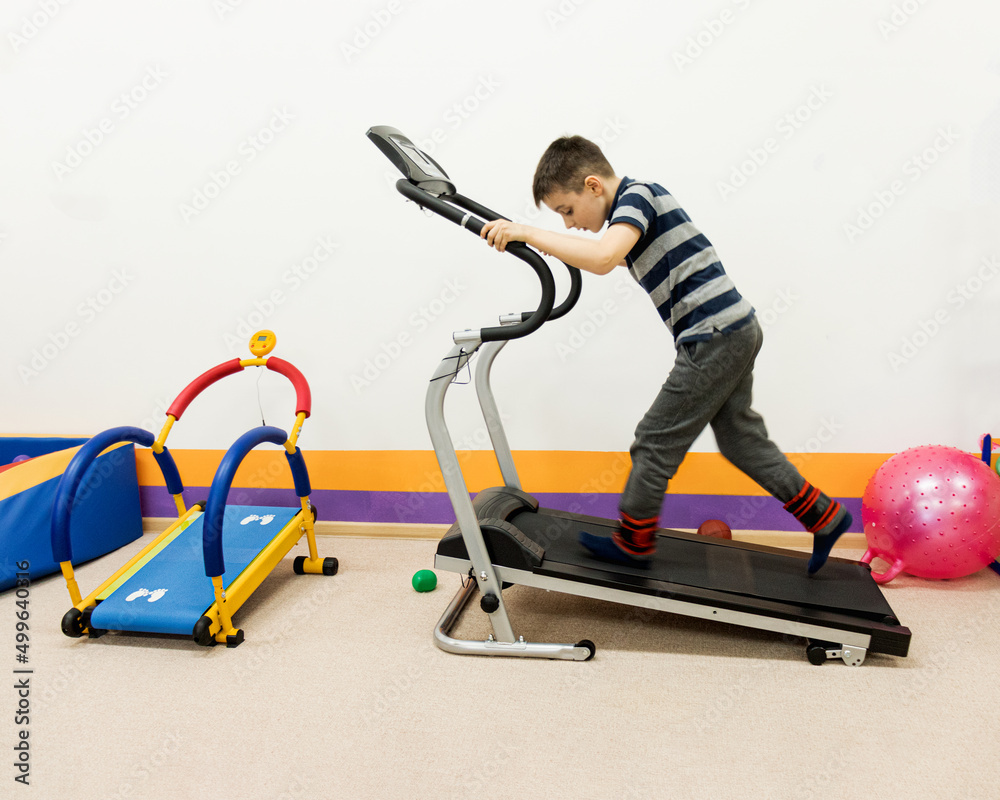 child runs on a treadmill in a children's gym. childrens simulators ...