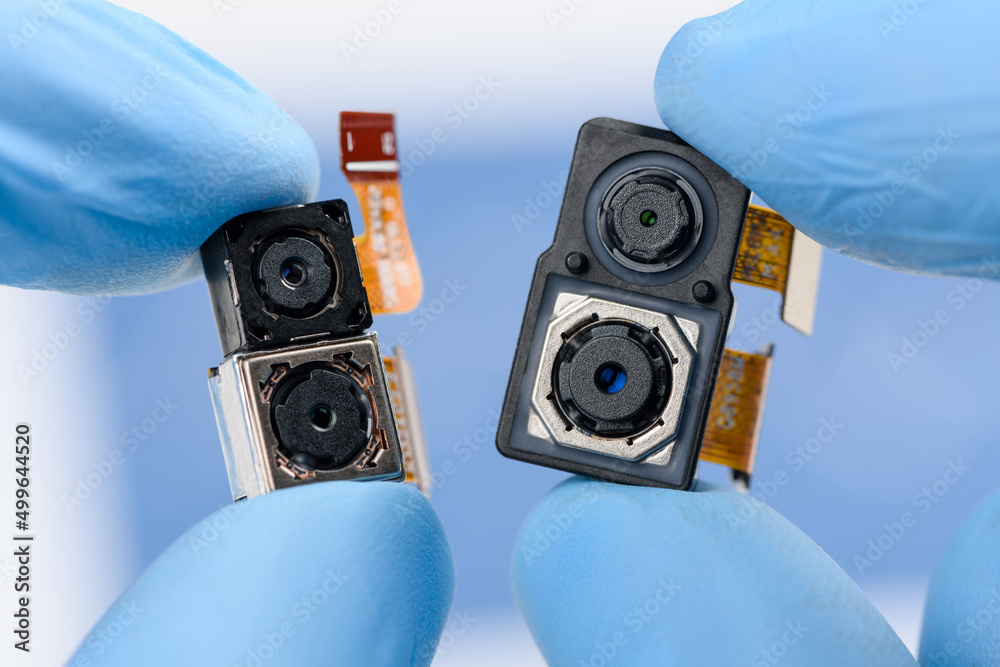 Smartphone single and dual camera modules in scientist hands. Different ...