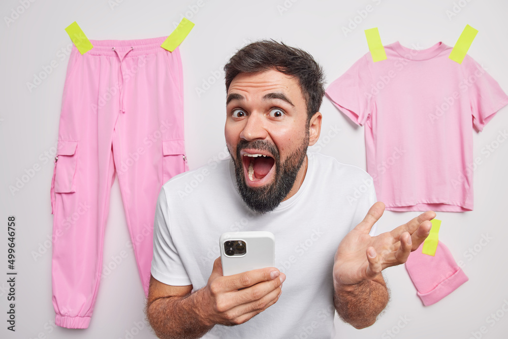 Confused amazed bearded European man shrugs shoulders from bewilderment ...