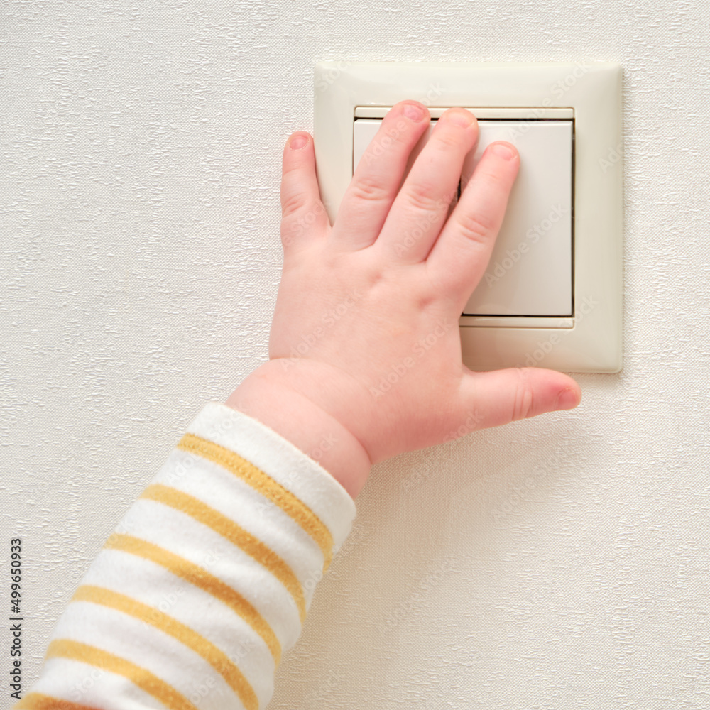 Toddler baby boy turns the light on and off with an electric switch ...