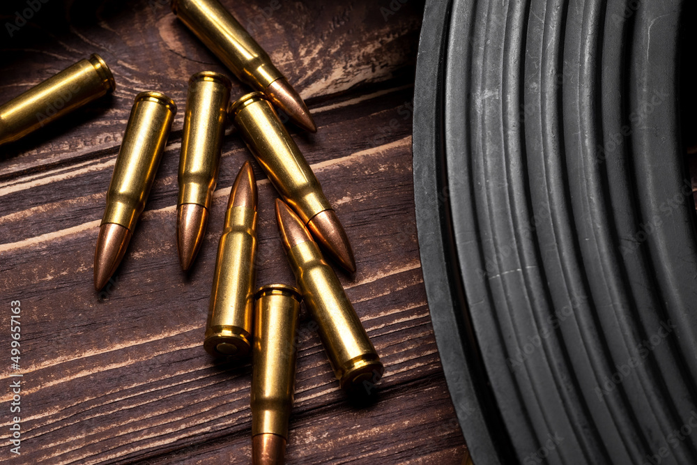 Bullets and Kalashnikov assault rifle on wooden background. Cartridges ...