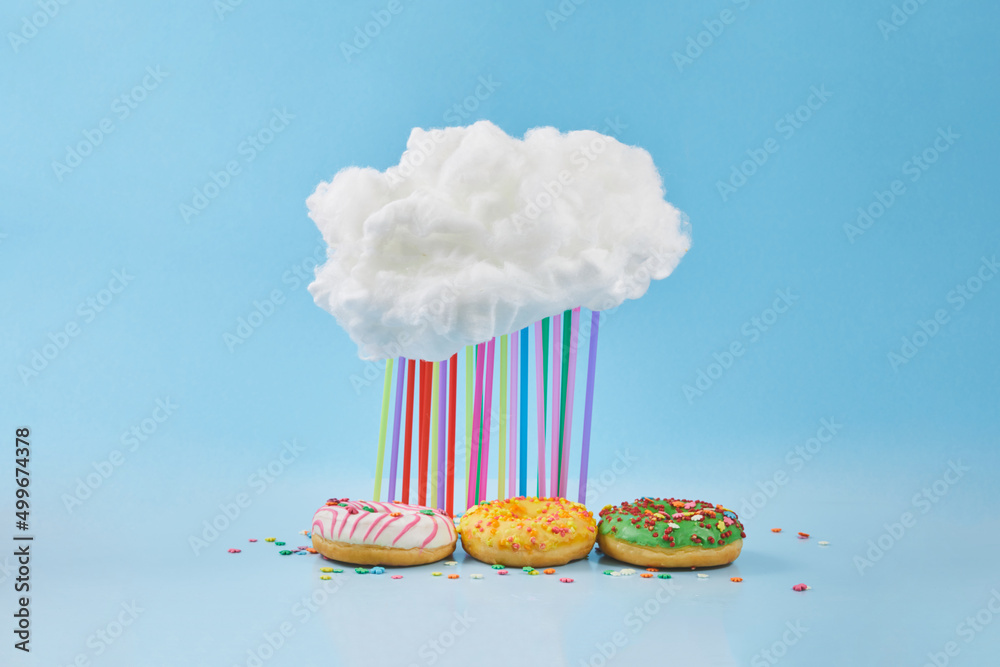 Different doughnuts under a small cloud and a rain of drinking straws ...