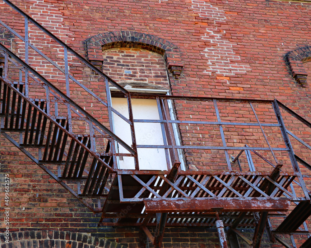 Rusted fire escape stair case on old red brick warehouse building ...
