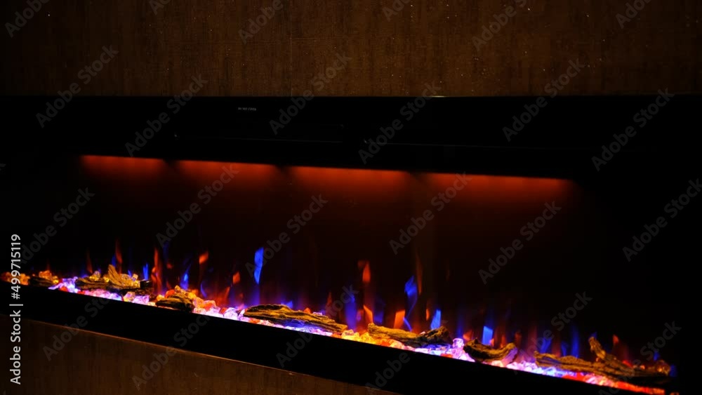 Side view on electric fireplace with artificial sparkling flame, decor ...