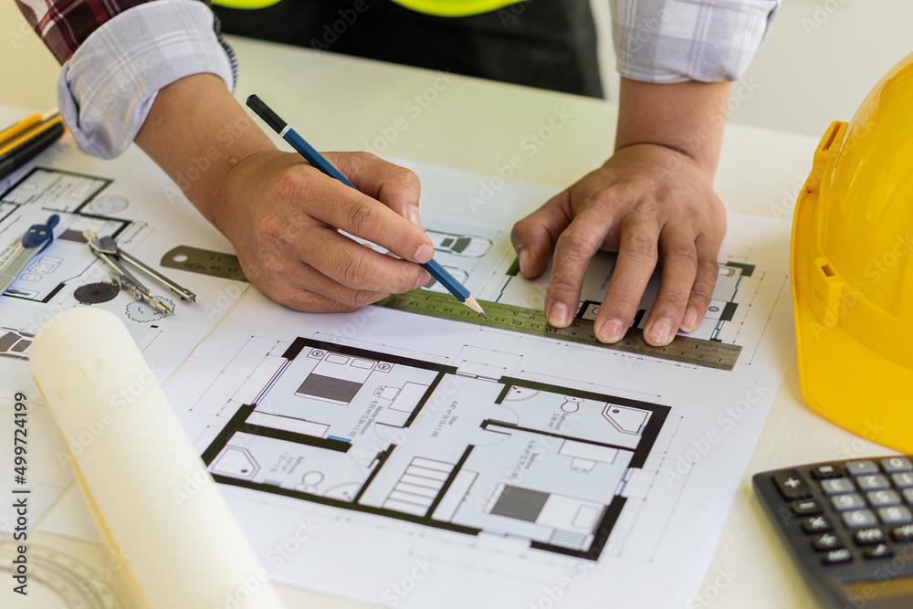 Professional architect working on blueprints and construction plans ...