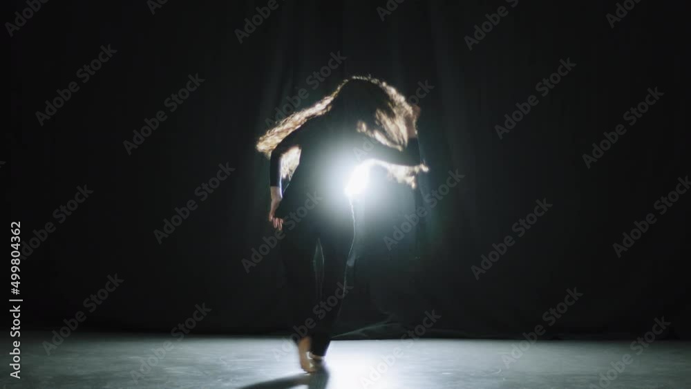 Active gorgeous graceful girl with long curly hair in black clothes in ...