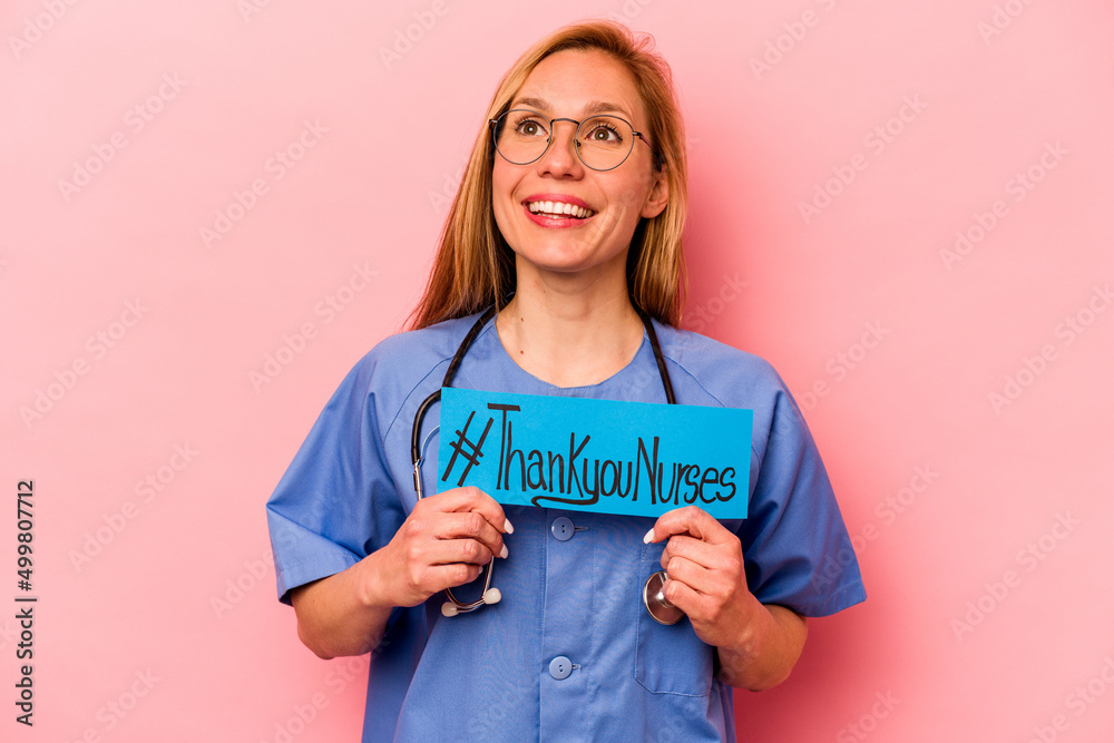 Young nurse woman holding thank you nurses placard isolated on pink ...