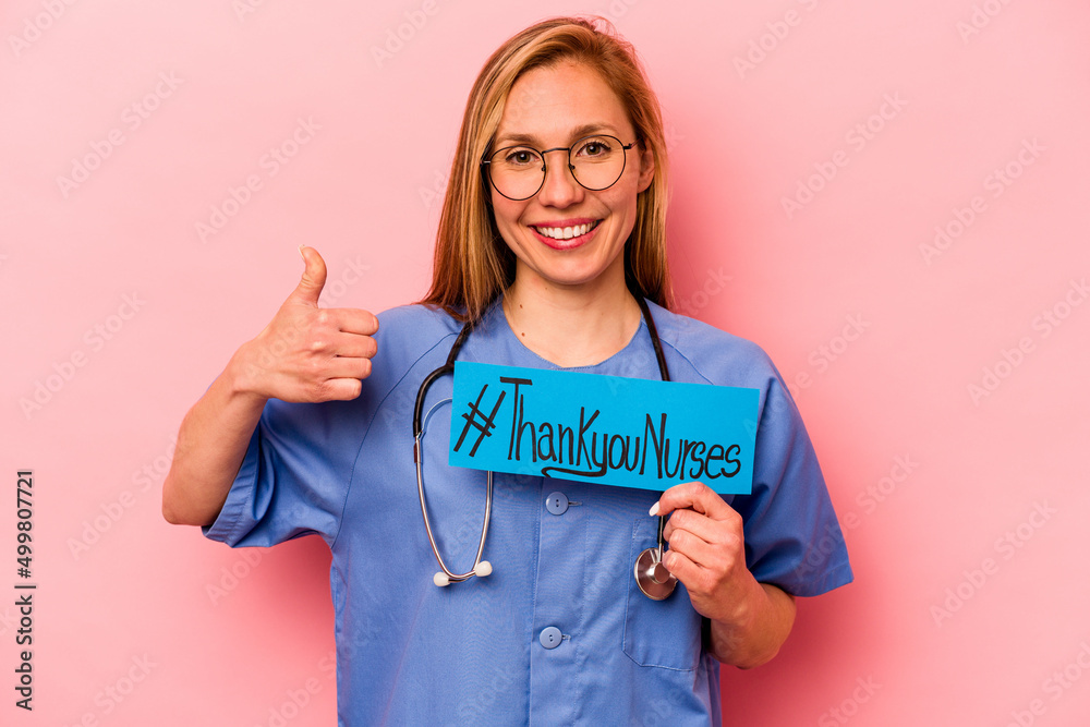 Young nurse woman holding thank you nurses placard isolated on pink ...