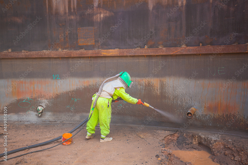 Female worker surface corrosion plate preparation by sand blasting ...
