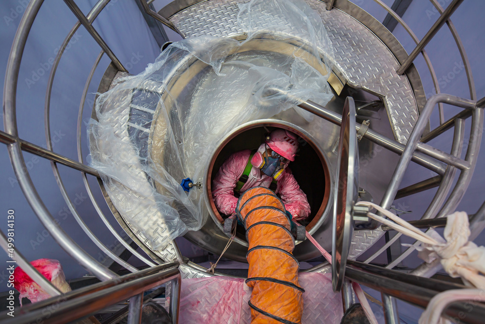 Top view male worker climb up the stairs into the tank stainless ...