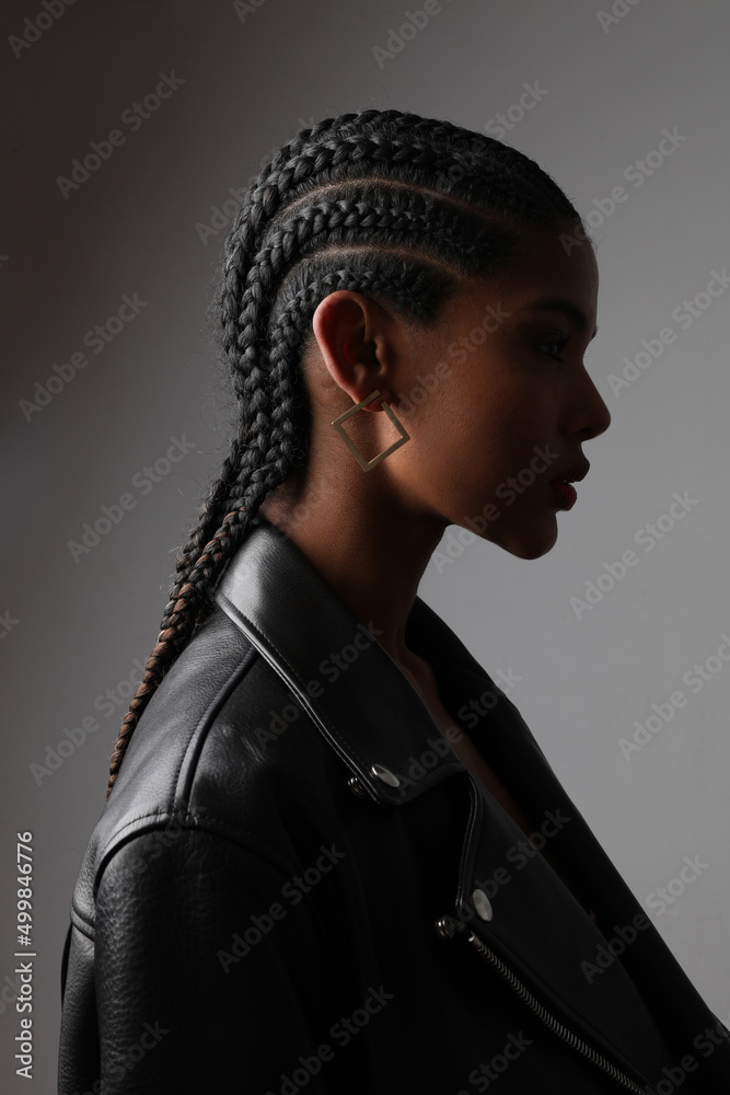 Vertical headshot of African young woman with braids posing on grey ...
