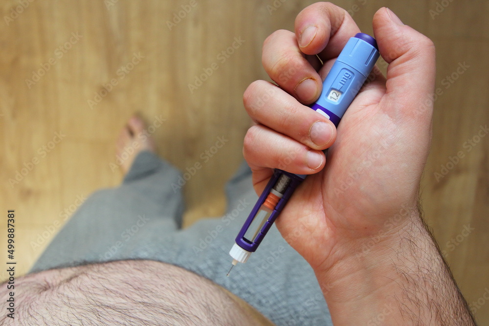 Overweight man applying diabetes medicine injection (syringe) into his ...